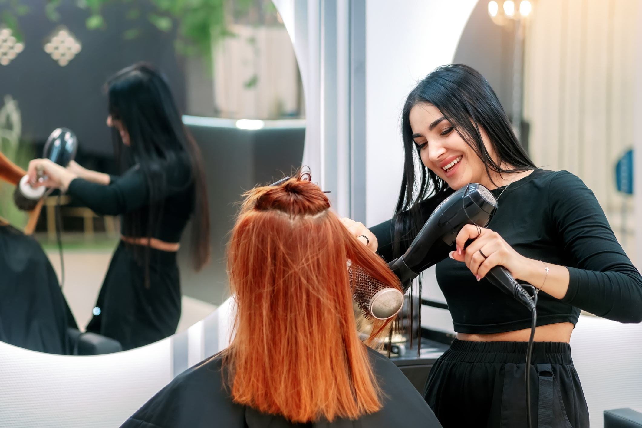 Hair styling in beauty salon. Woman does her hair in modern beauty ...